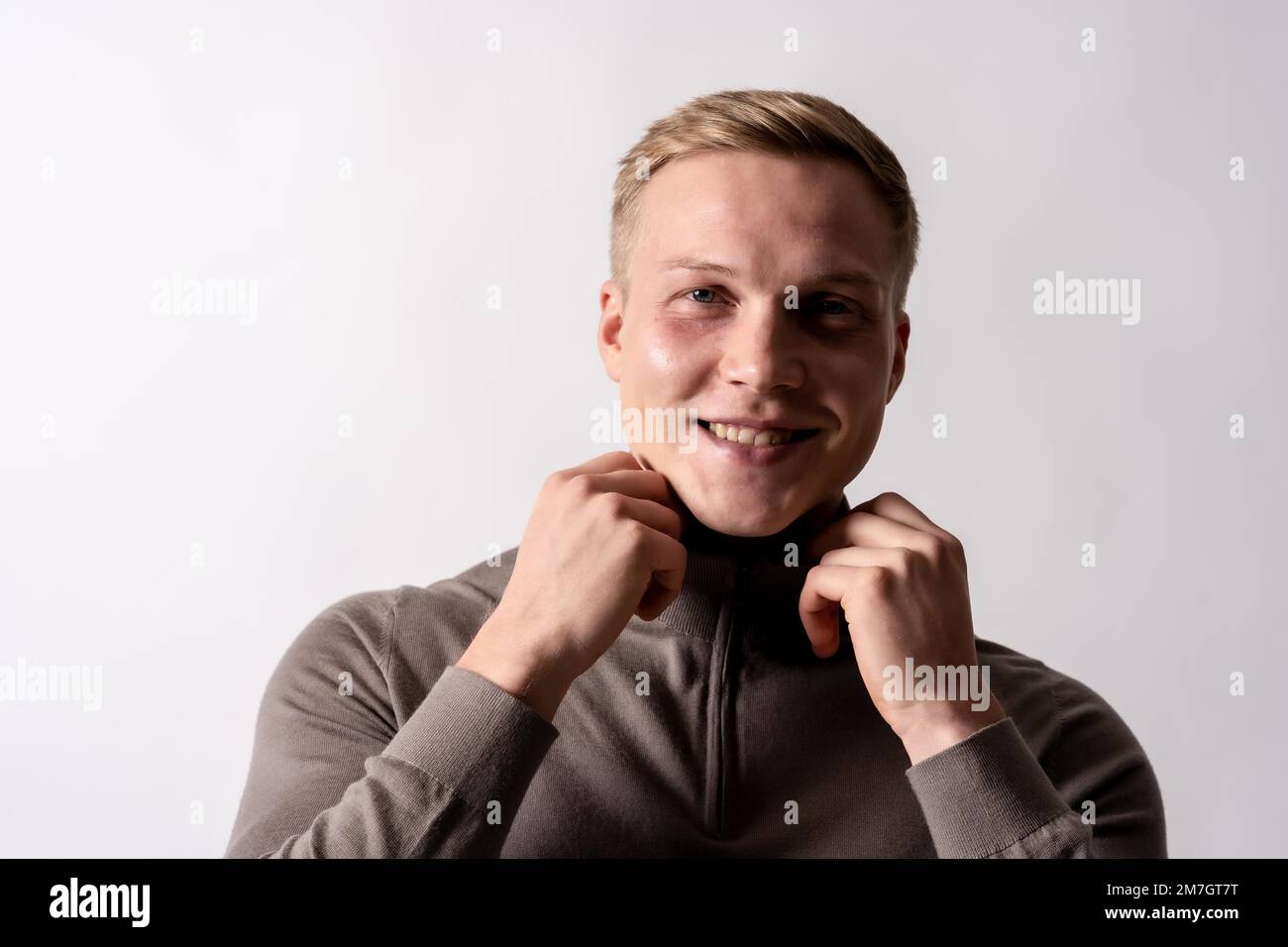 Portrait of an attractive blond german model with brown sweater on a ...