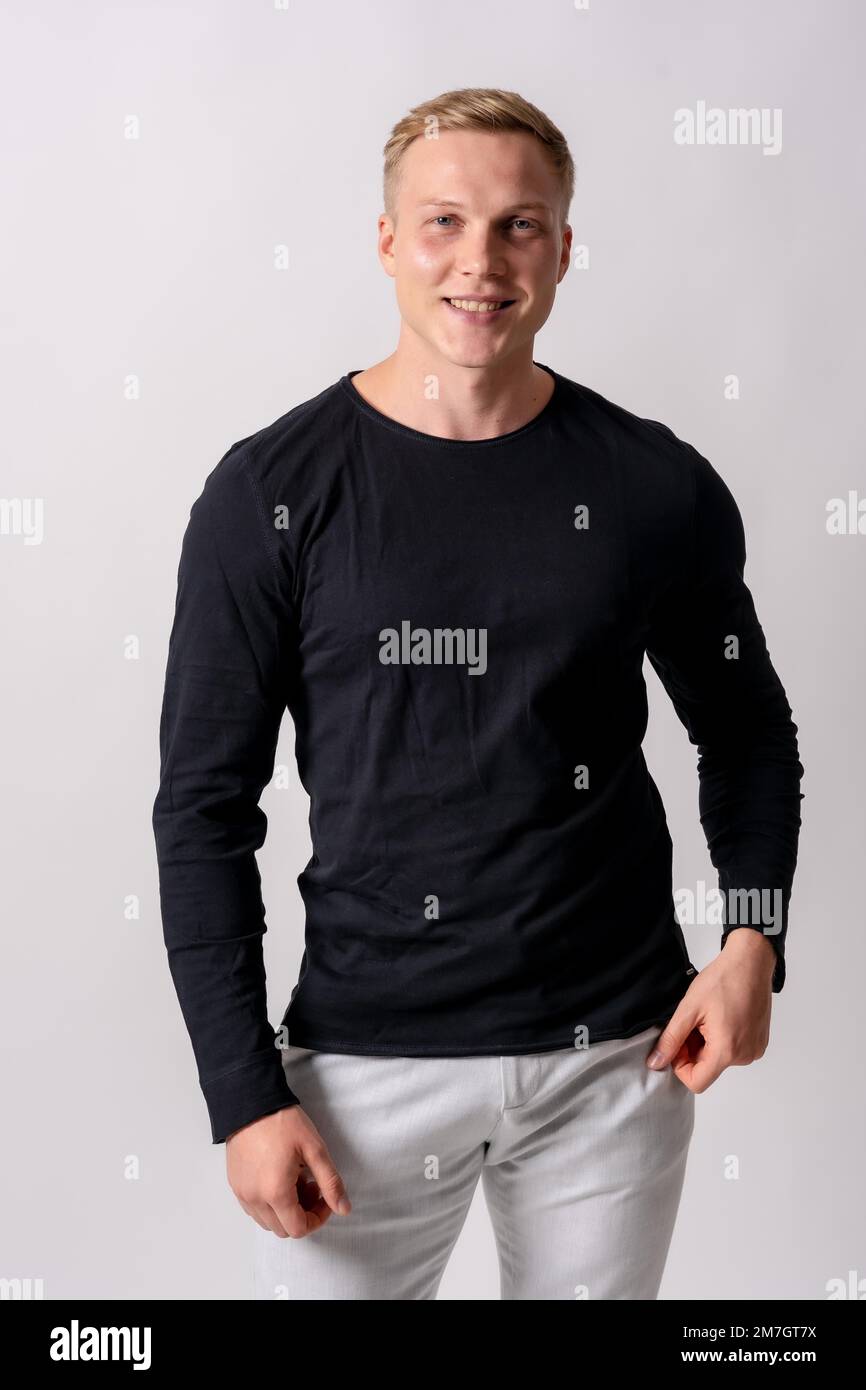 Attractive blond german model with black sweater on a white background ...