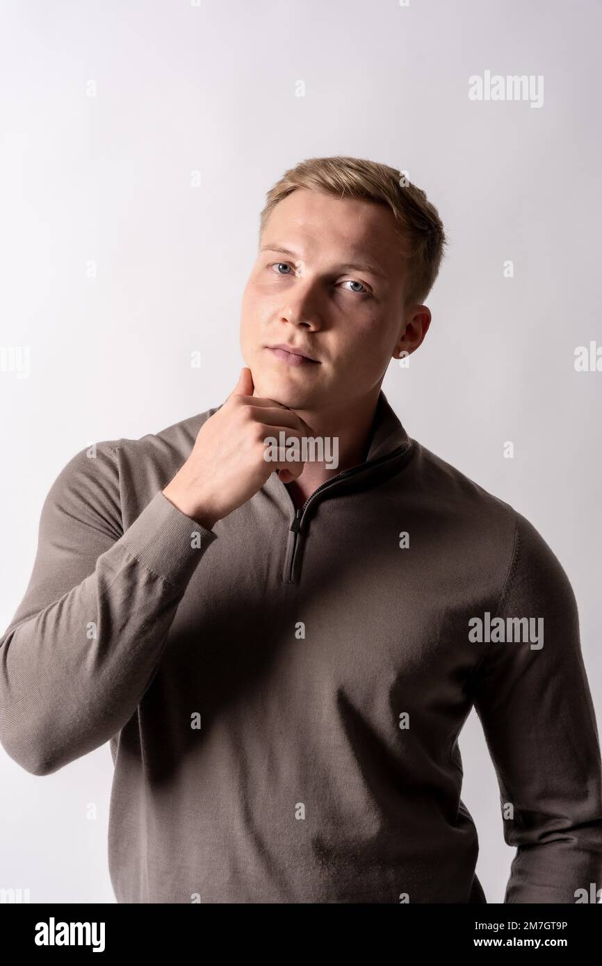 Portrait of a blond german model with a brown sweater on a white ...