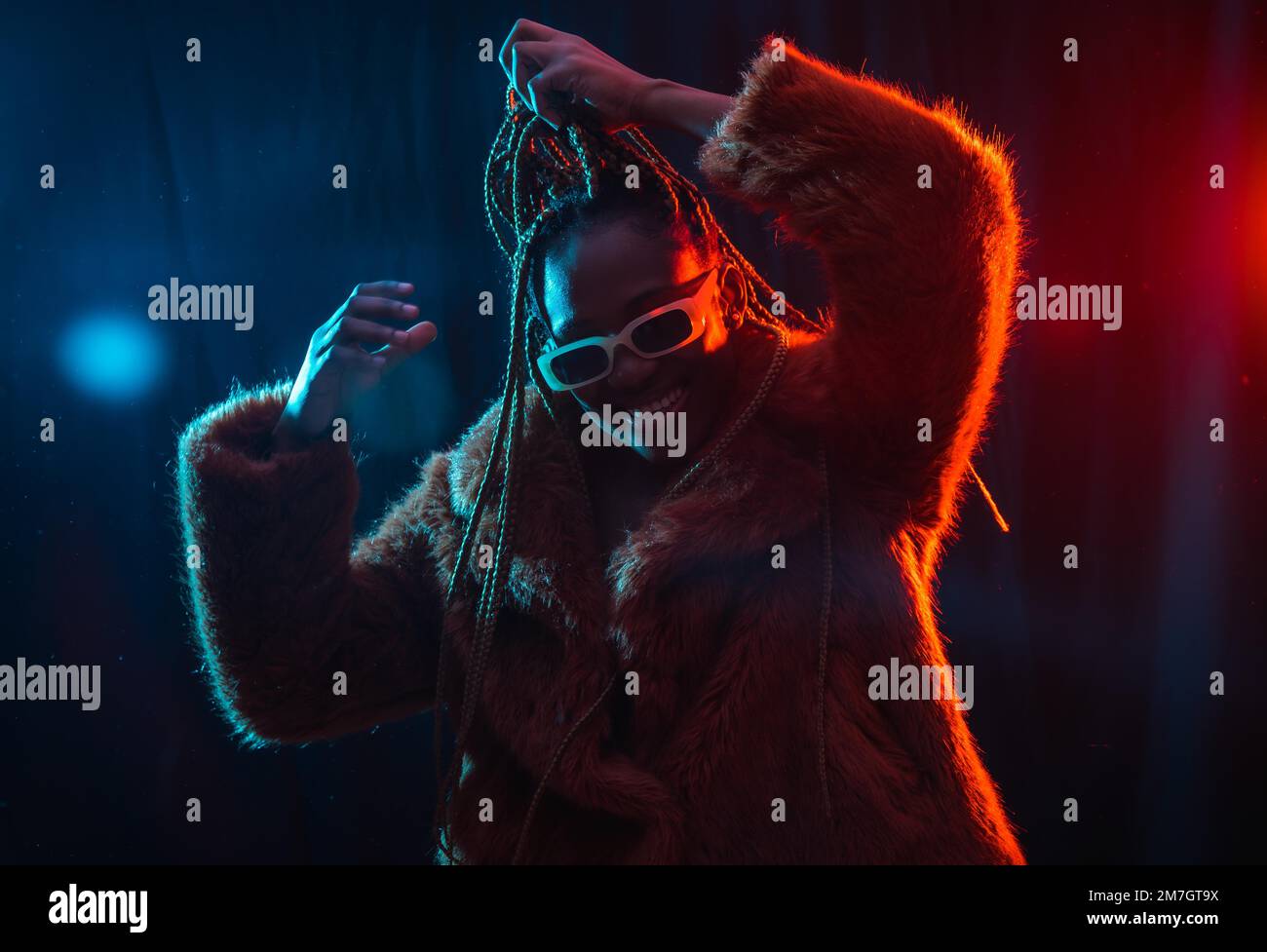 Young African woman with braids with blue and red led lights, moving ...