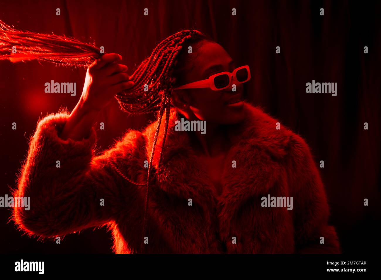 Young african woman with braids with red led lights, trap dancer in a ...