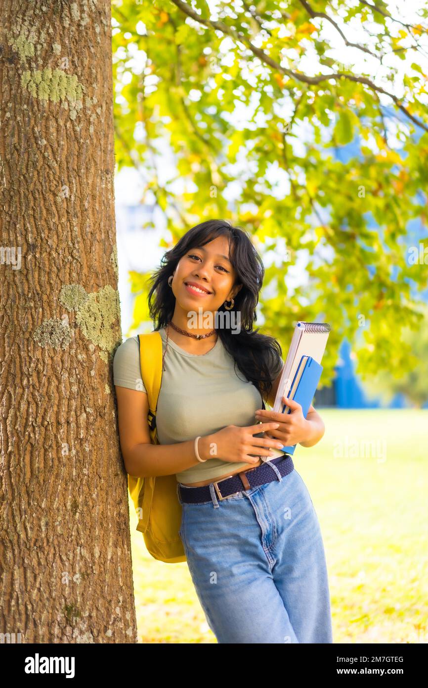 Asian girl on campus, smiling at university under tree with block in ...