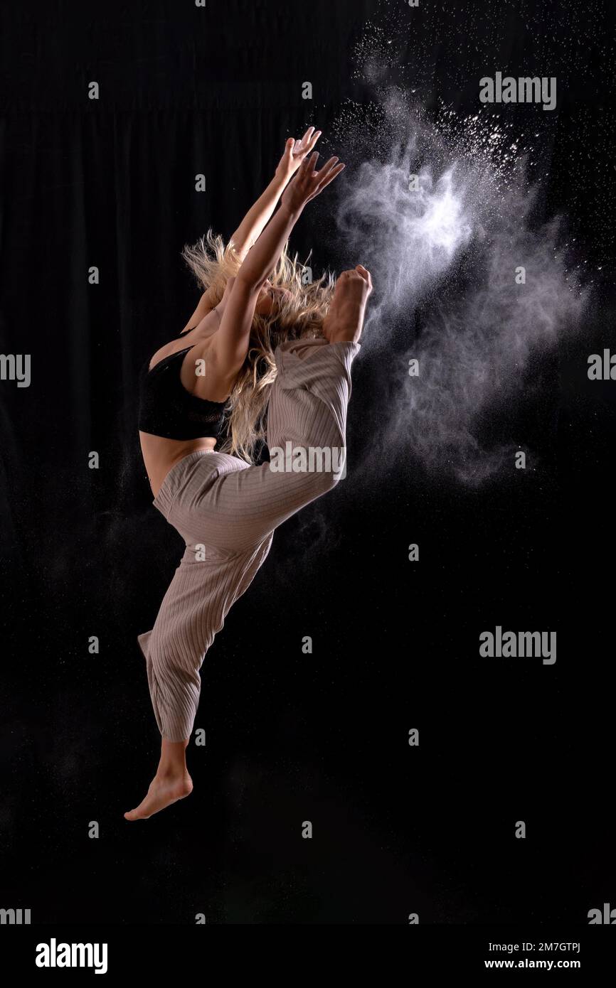 Young dancer performing a jump in studio photo session with a black background, ballet Stock ...