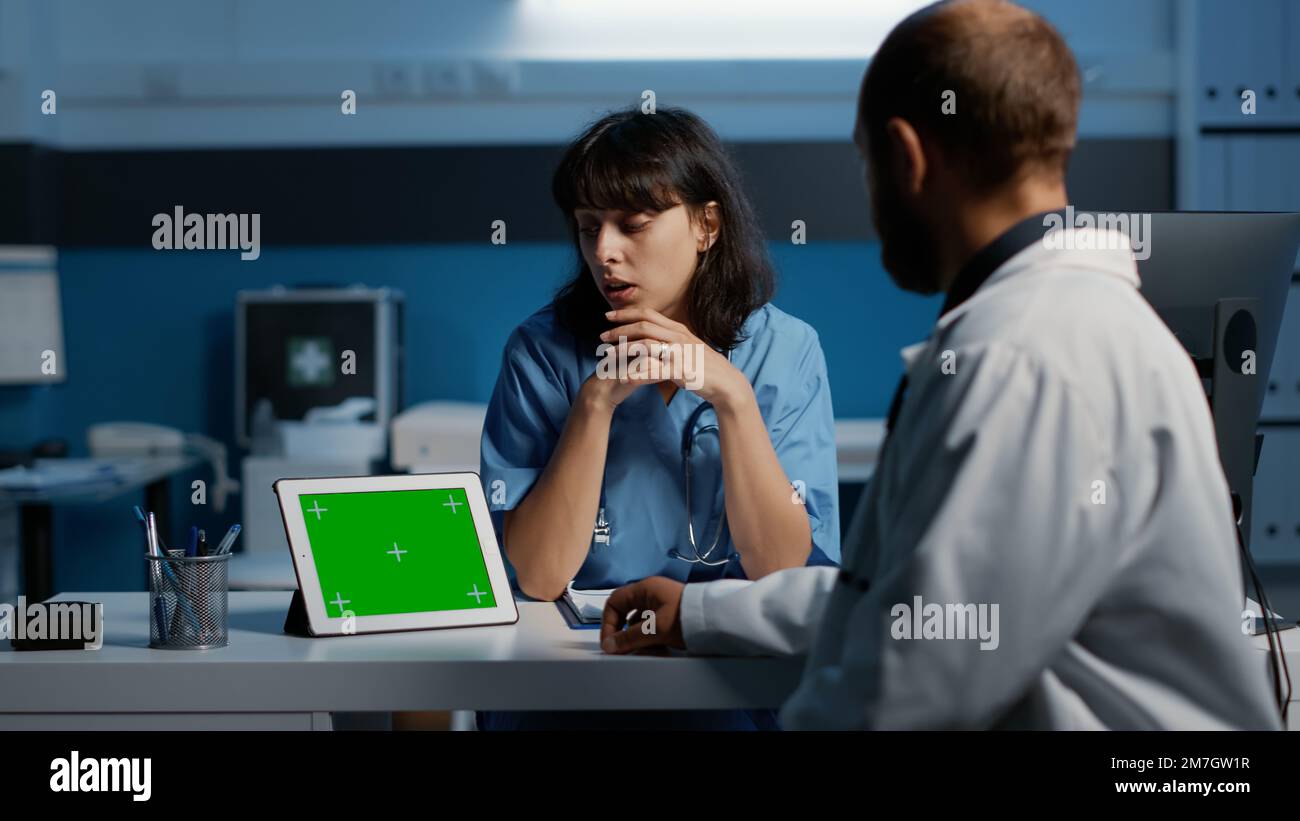 Nure discussing medical report with physician while analyzing tablet ...