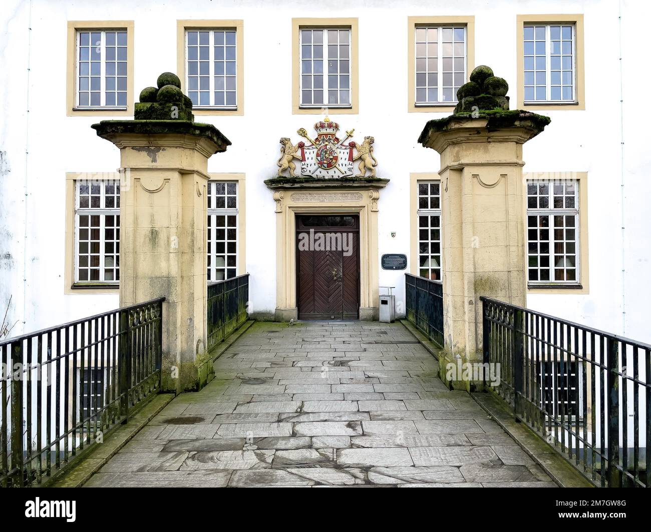 View over bridge from moat to entrance door of historic moated castle Burg Schloss Borbeck ...