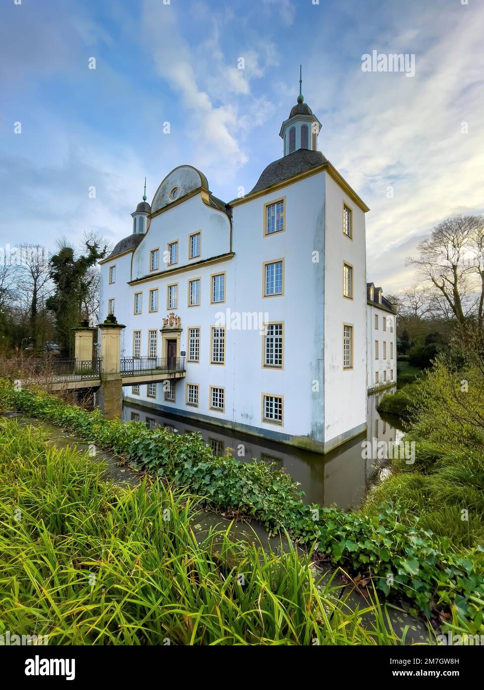 View over moat to front entrance corner tower of historic moated castle ...