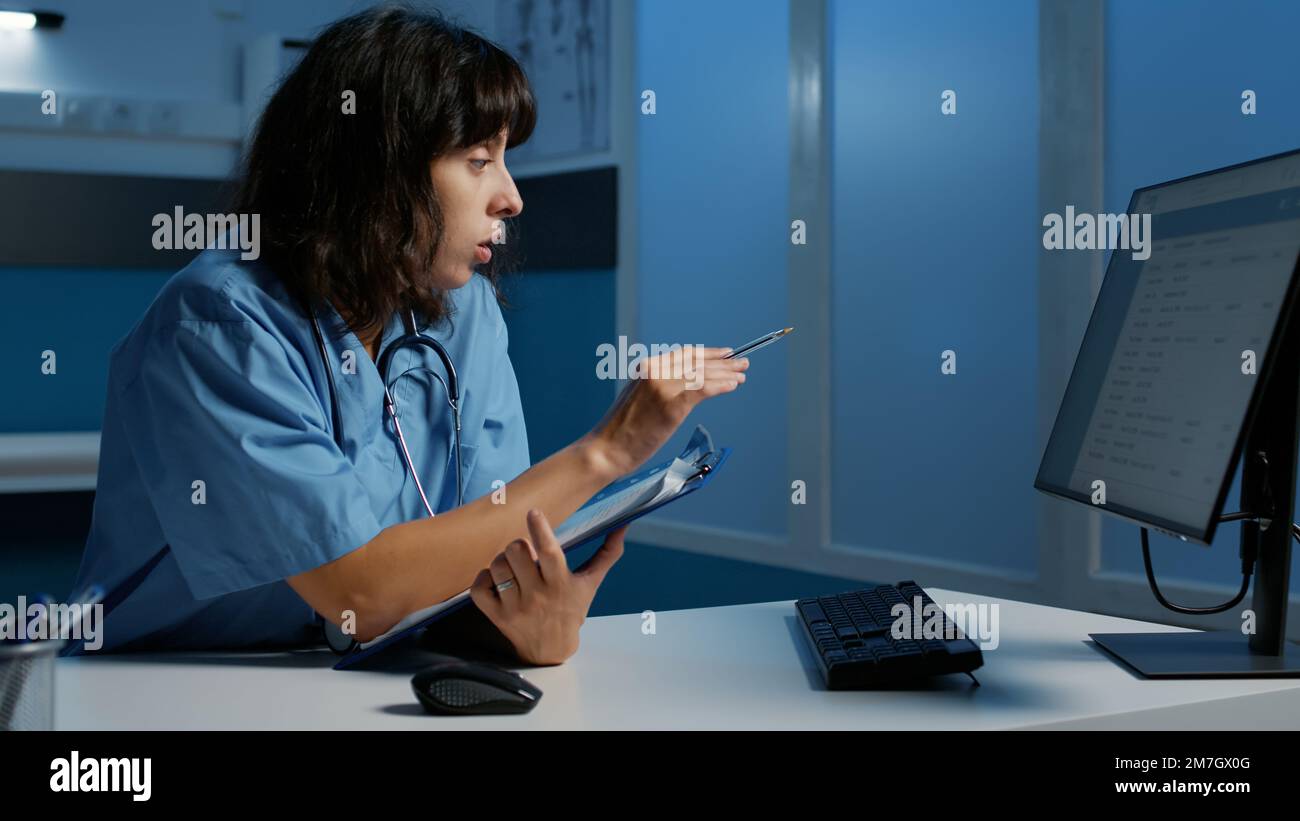 Practitioner assistant with blue uniform and stethoscope analyzing ...