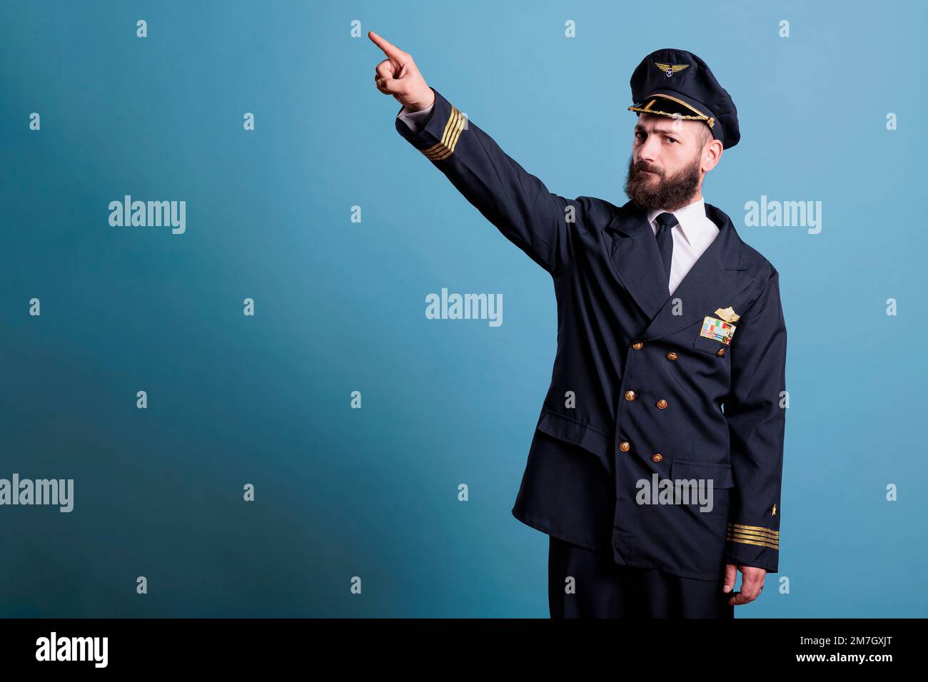 Airplane pilot pointing at sky with index finger, wearing professional ...