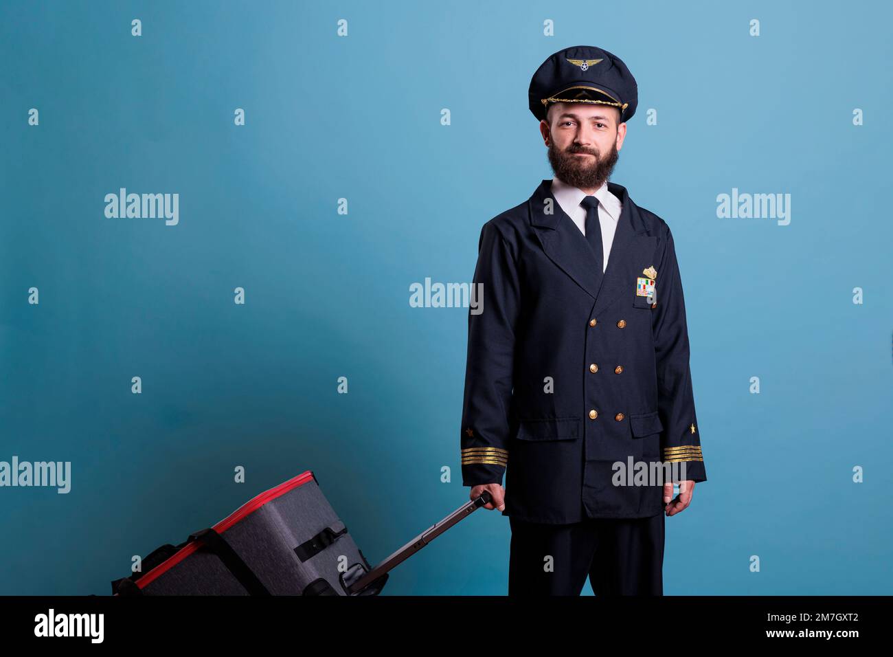 Airplane captain in professional airline uniform standing with suitcase ...