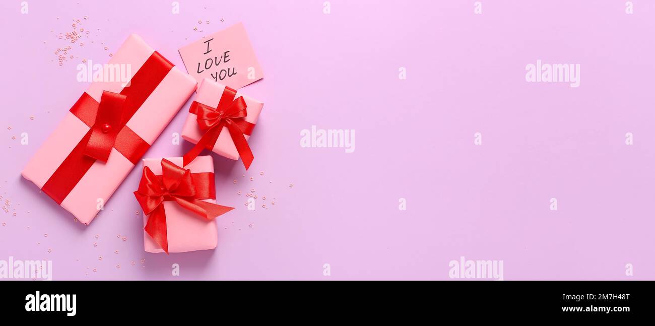 Gifts and sticky note with text I LOVE YOU on lilac background with ...