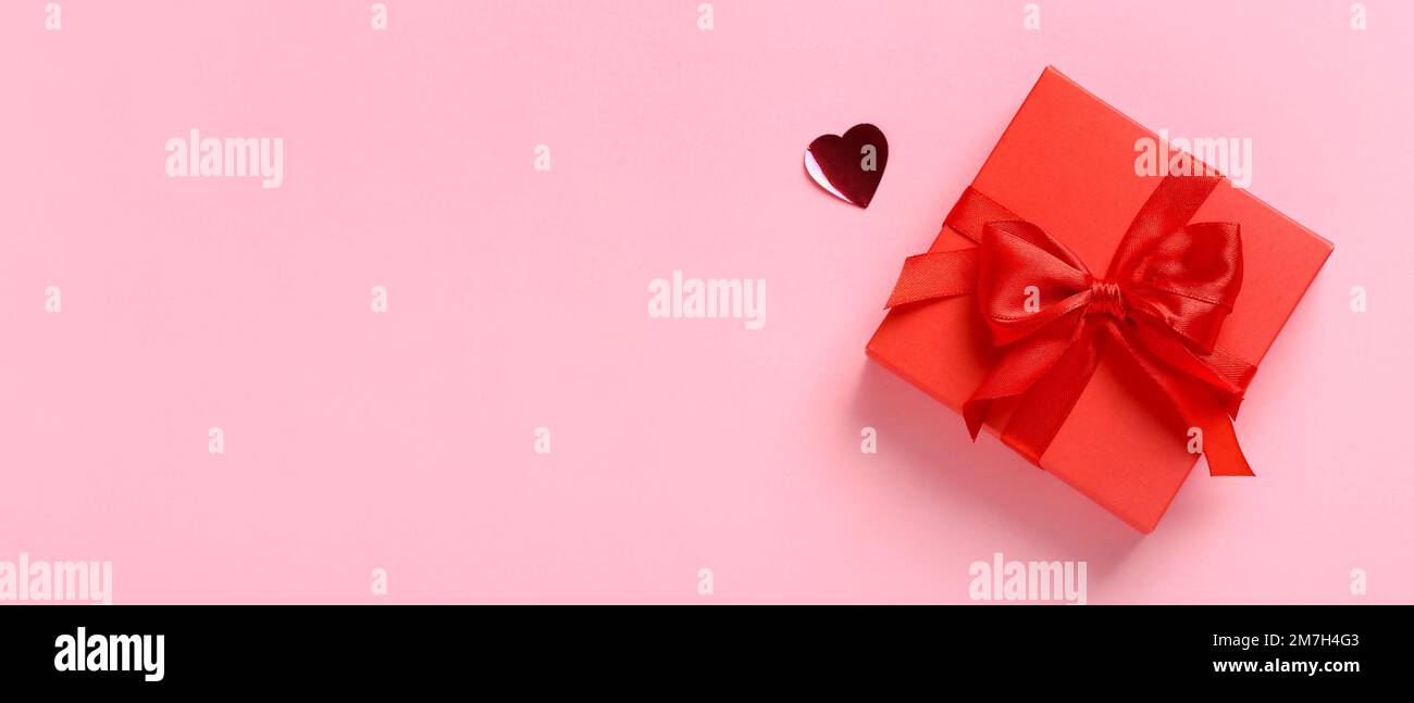 Red gift box and heart on pink background with space for text ...