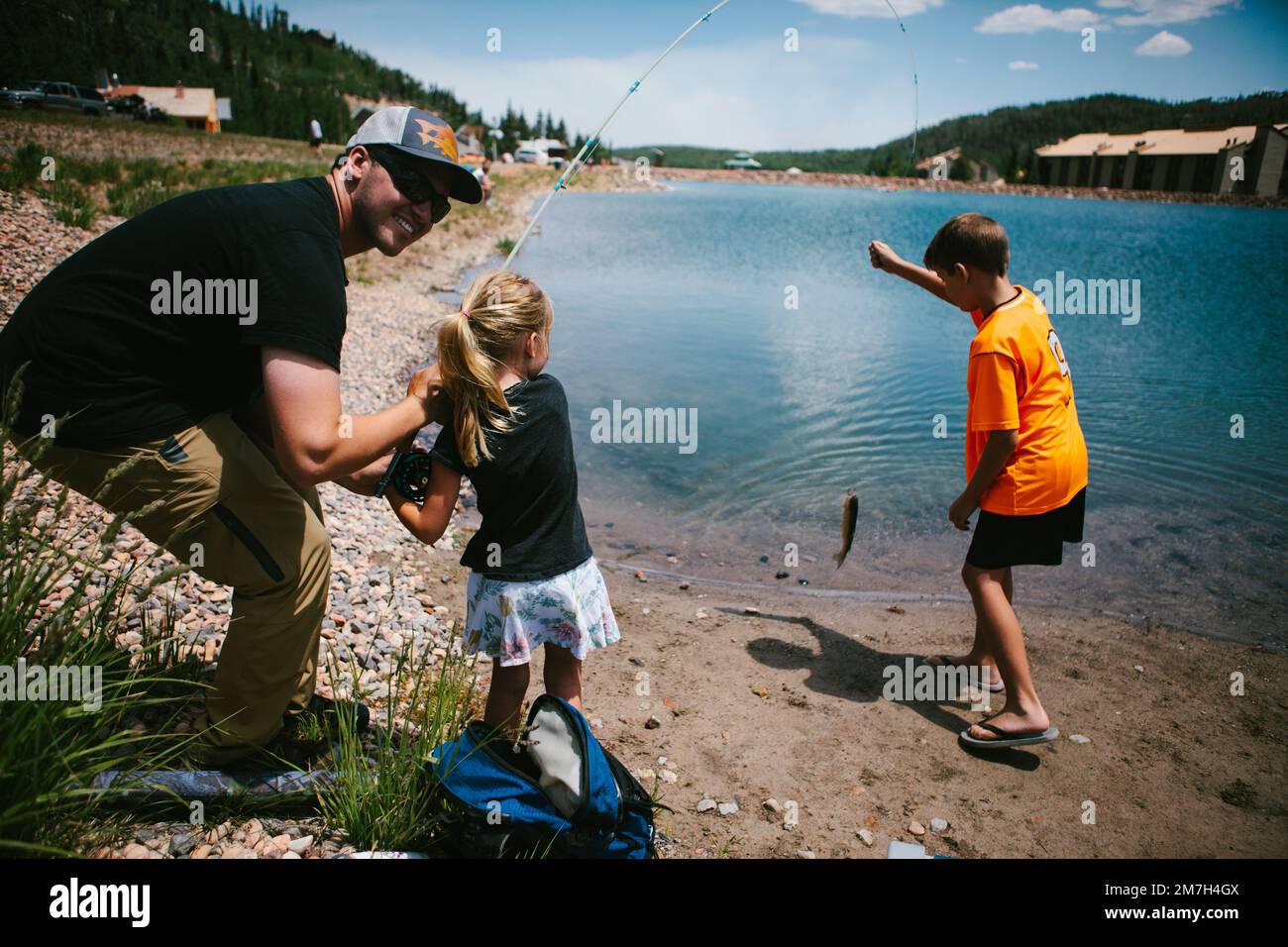 Family catches fish on vacation lakeside in the mountains Stock Photo ...