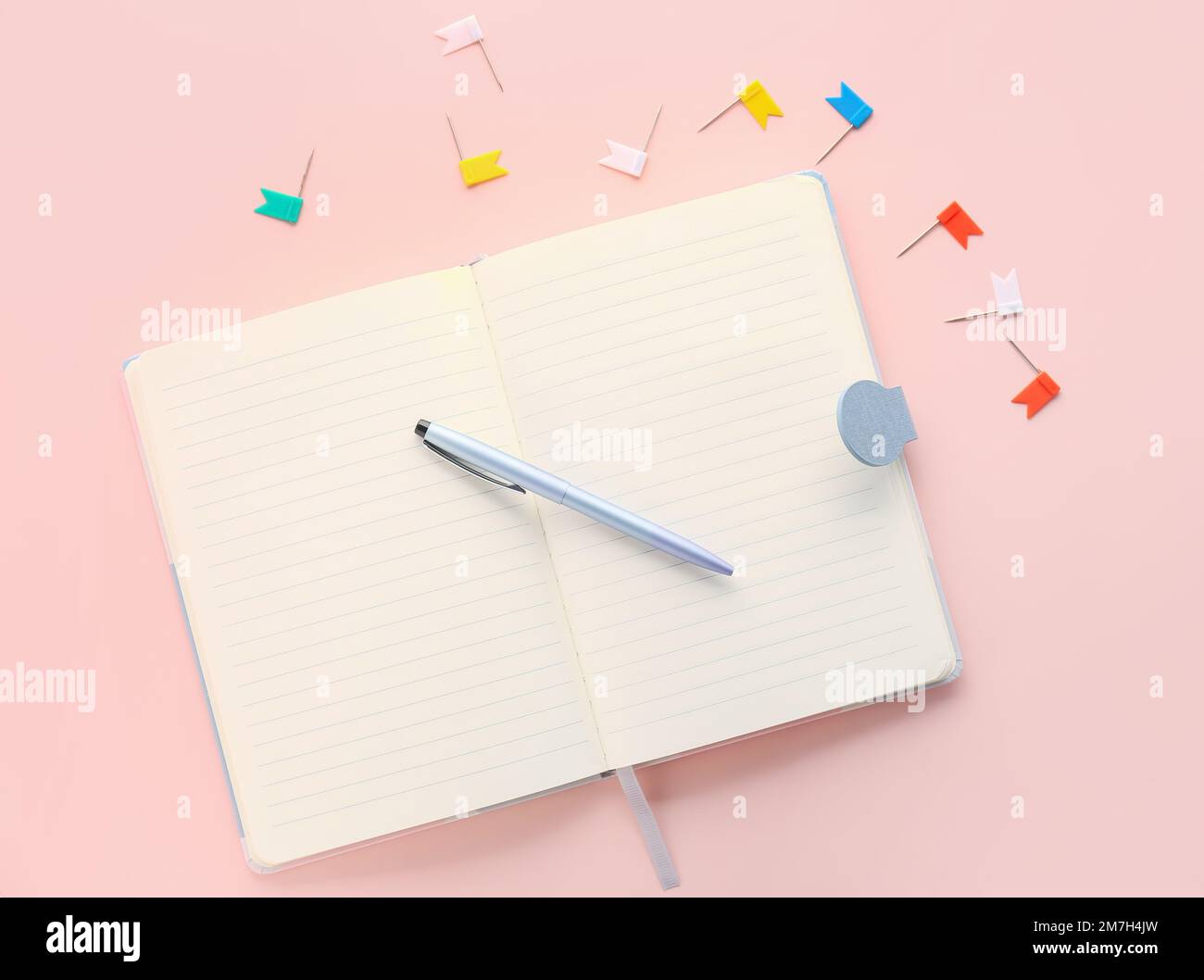 Open notebook, pen and pins on pink background Stock Photo - Alamy