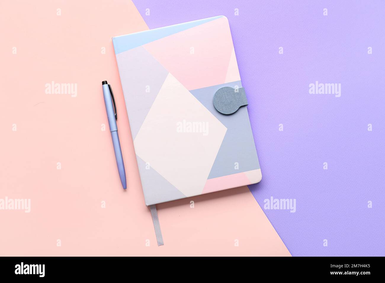 Stylish notebook with pen on color background Stock Photo - Alamy