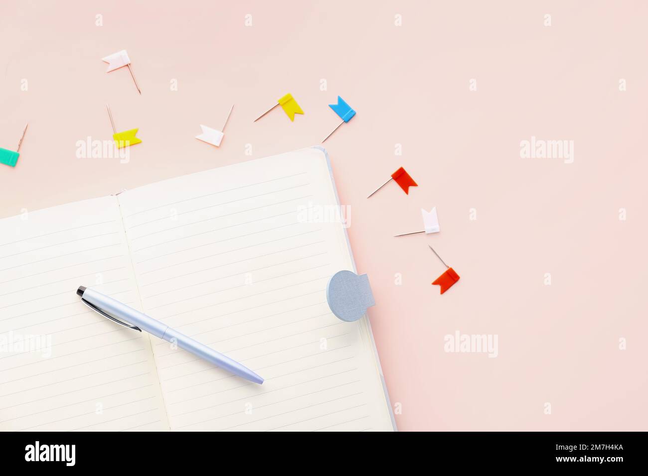 Open notebook, pen and pins on pink background Stock Photo - Alamy