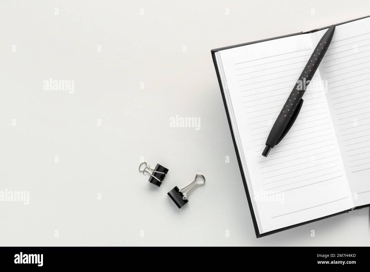 Notebook, pen and binder clips on light background Stock Photo - Alamy