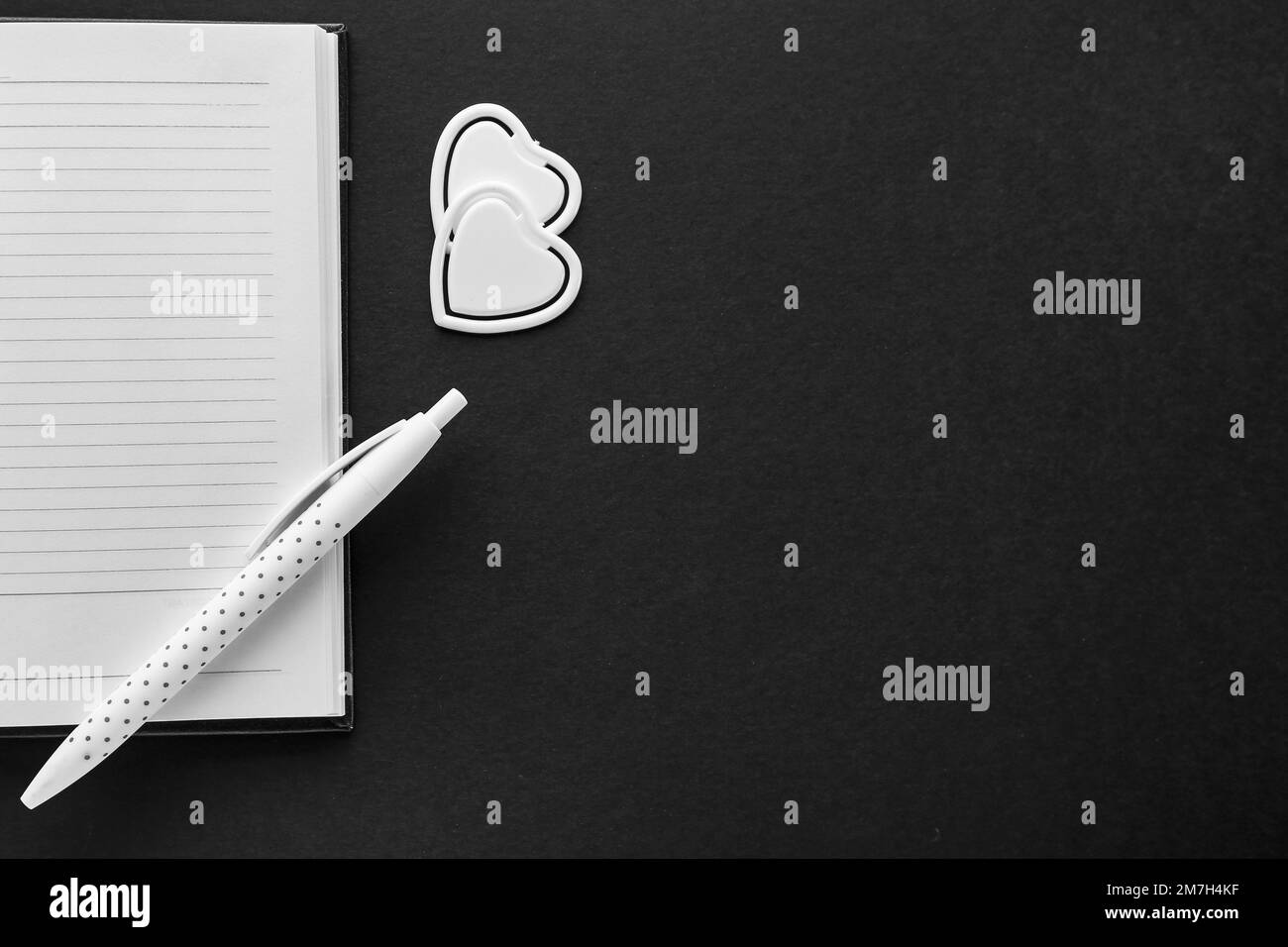 Notebook, pen and paper clips on dark background Stock Photo - Alamy
