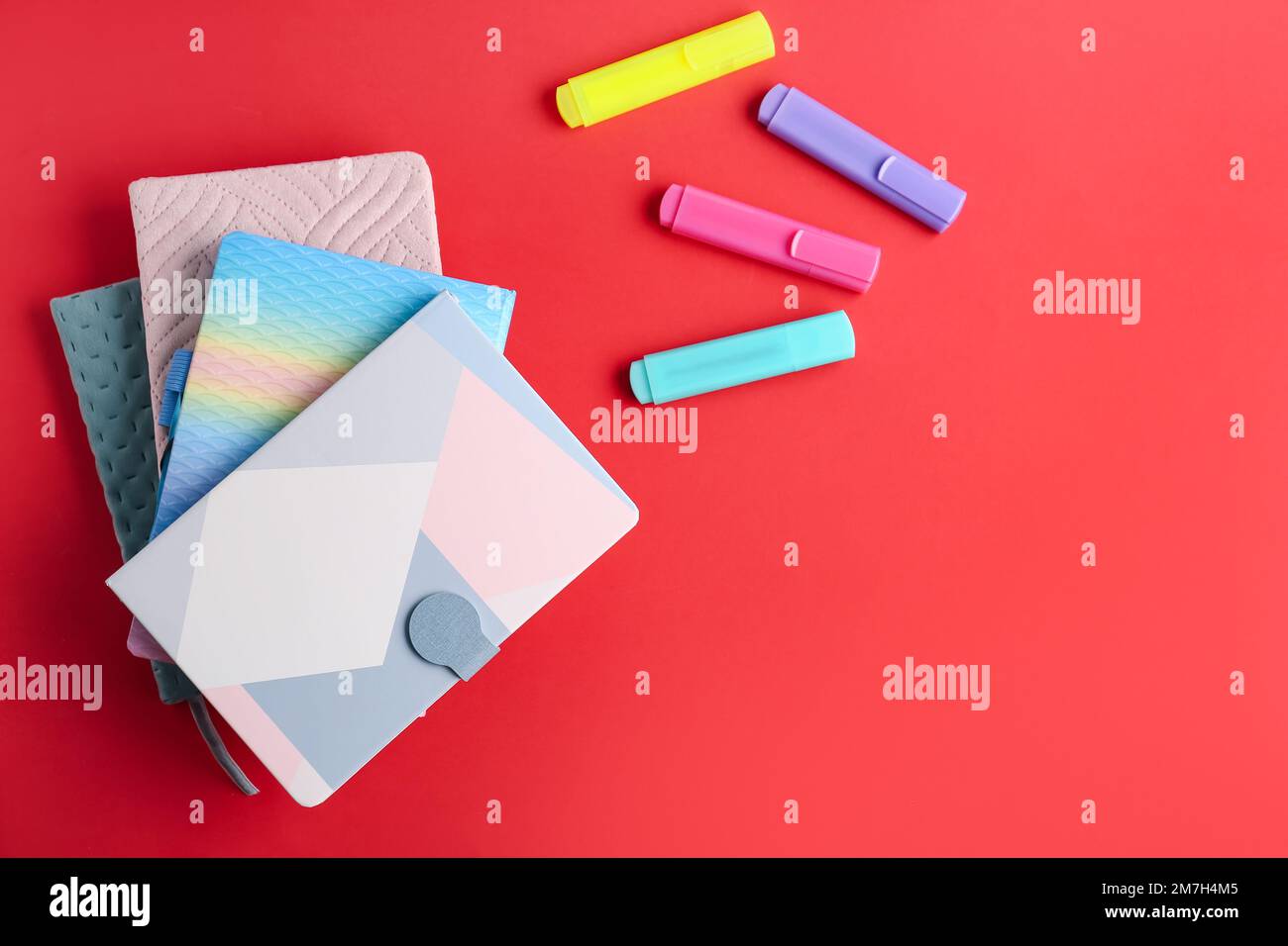 Stack of different notebooks and markers on red background Stock Photo ...