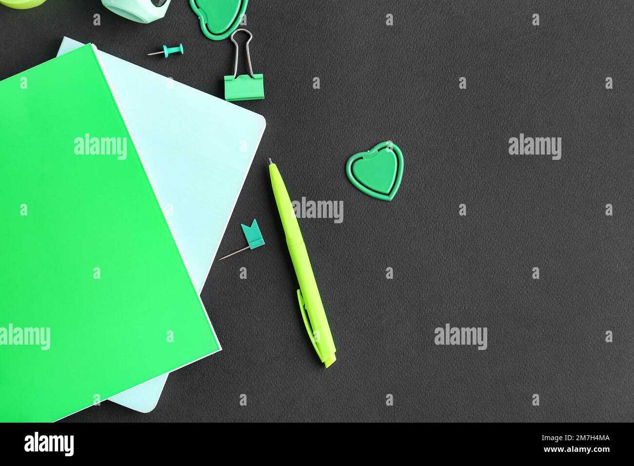 Composition with green stationery on dark background Stock Photo - Alamy