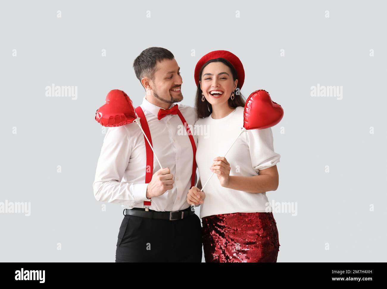 Happy couple in love with balloons on grey background. Valentine's Day ...