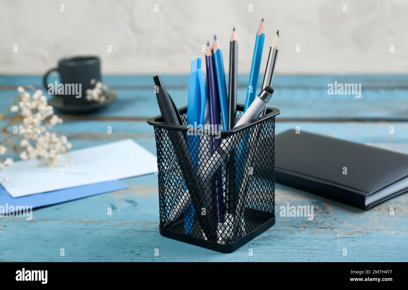 Notebook, envelopes, holder with stationery and flowers on wooden ...