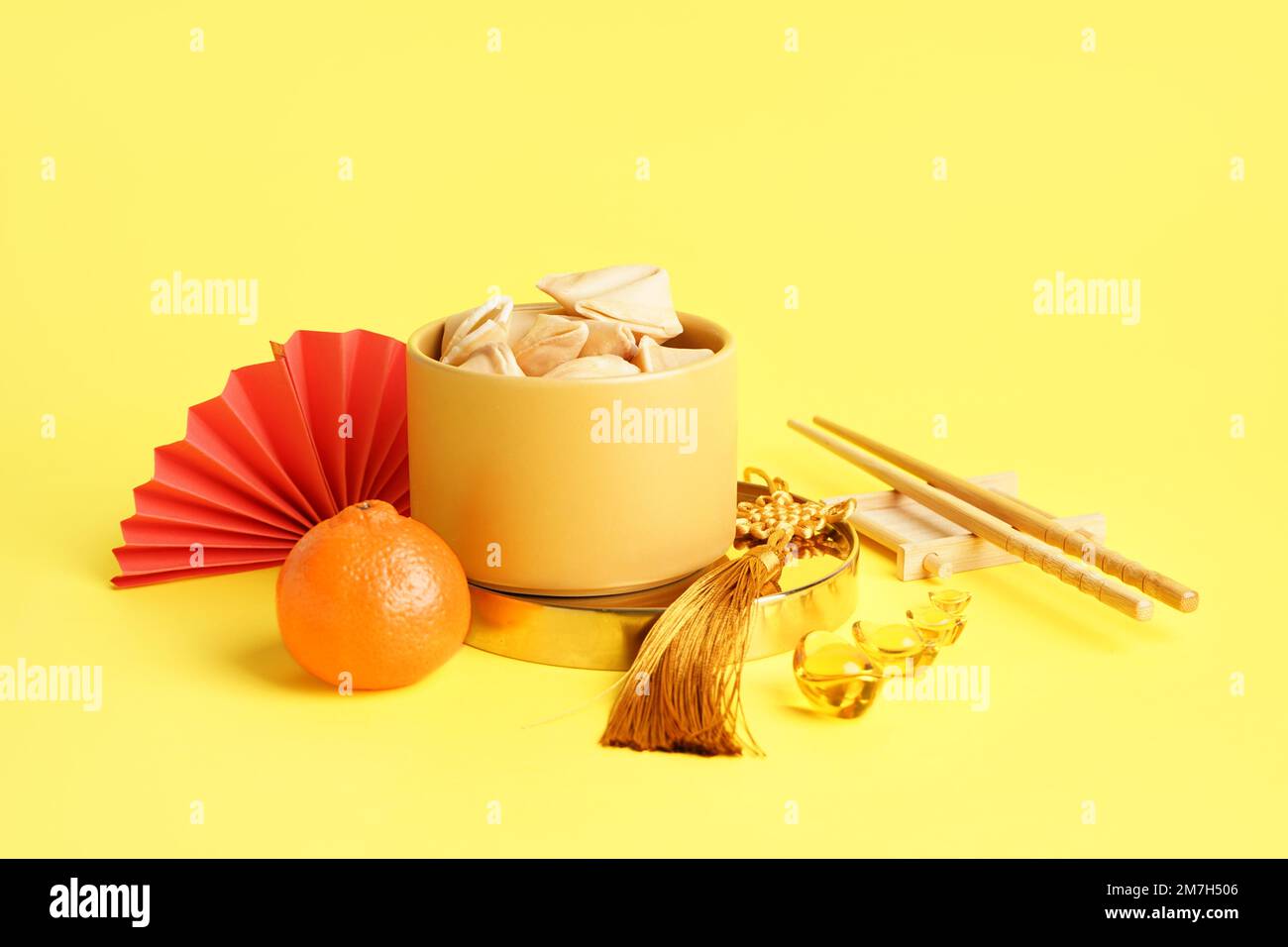 Bowl of fortune cookies, mandarin and Chinese symbols on yellow ...
