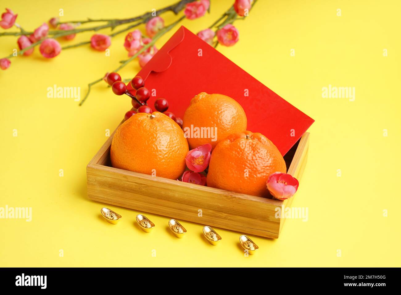 Box with mandarins, red envelope and Chinese symbols on yellow ...