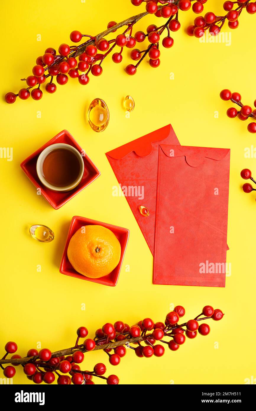 Red envelopes, cup of tea, mandarin and Chinese symbols on yellow ...