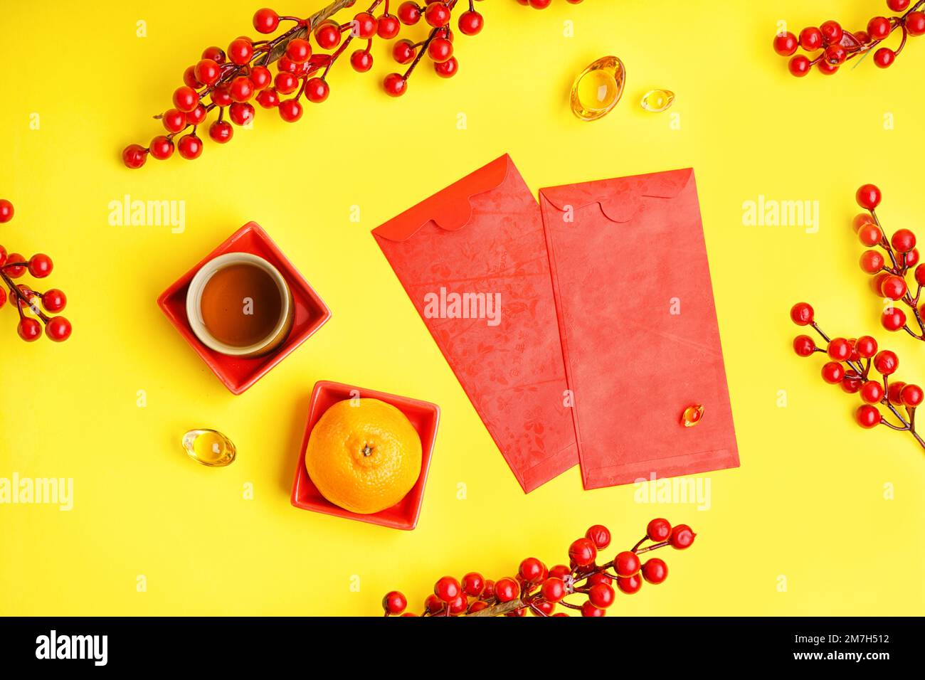 Red envelopes, cup of tea, mandarin and Chinese symbols on yellow ...