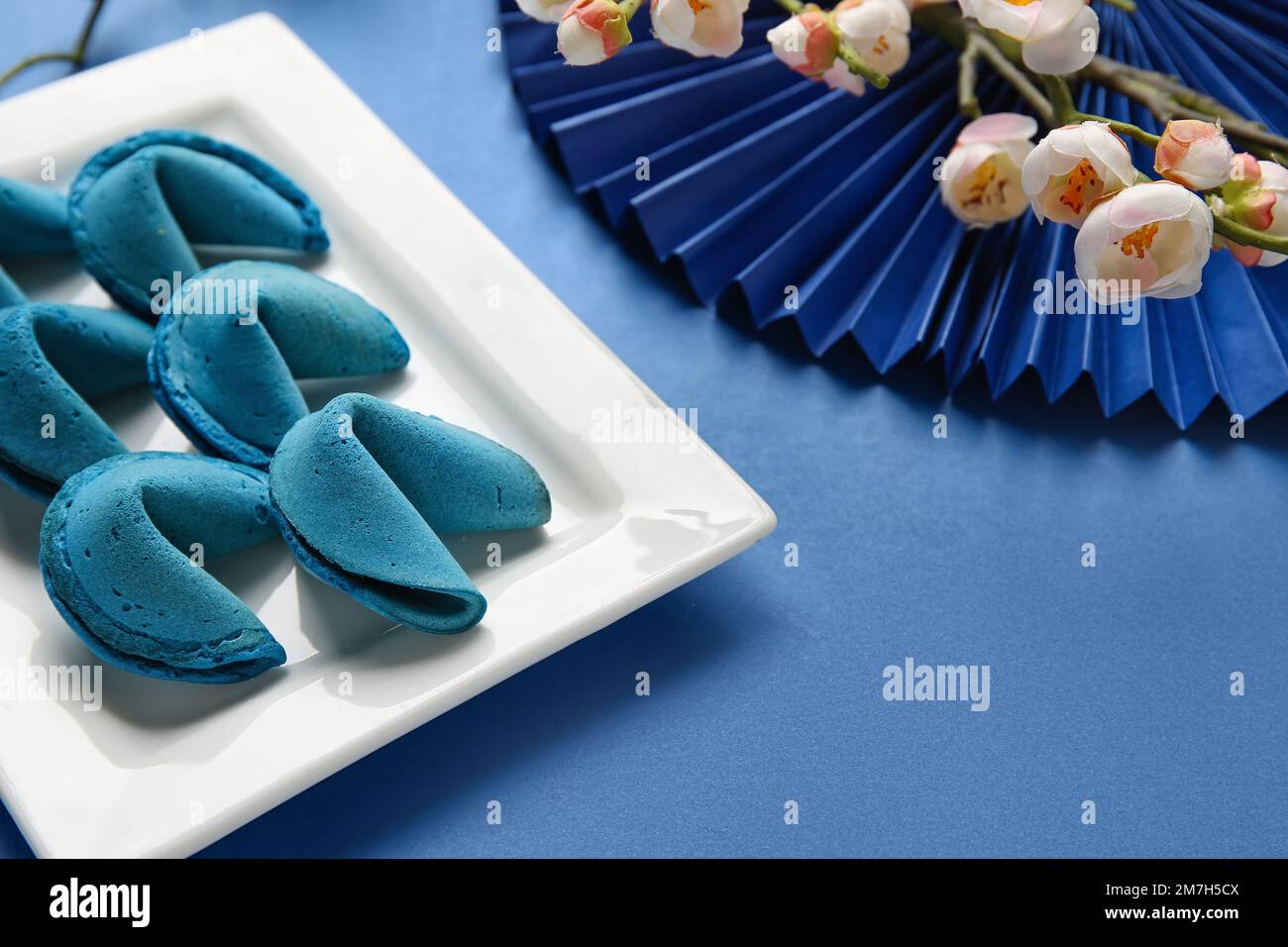 Plate with fortune cookies and Chinese symbols on blue background ...