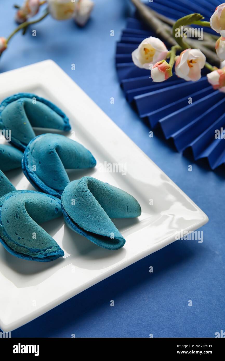 Plate with fortune cookies and Chinese symbols on blue background ...