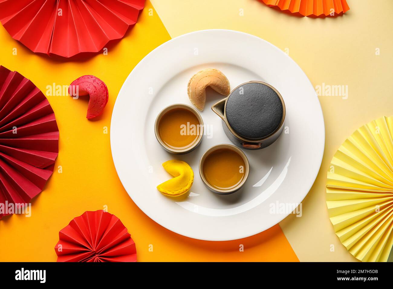 Plate with fortune cookies, teapot, cups and Chinese symbols on color ...