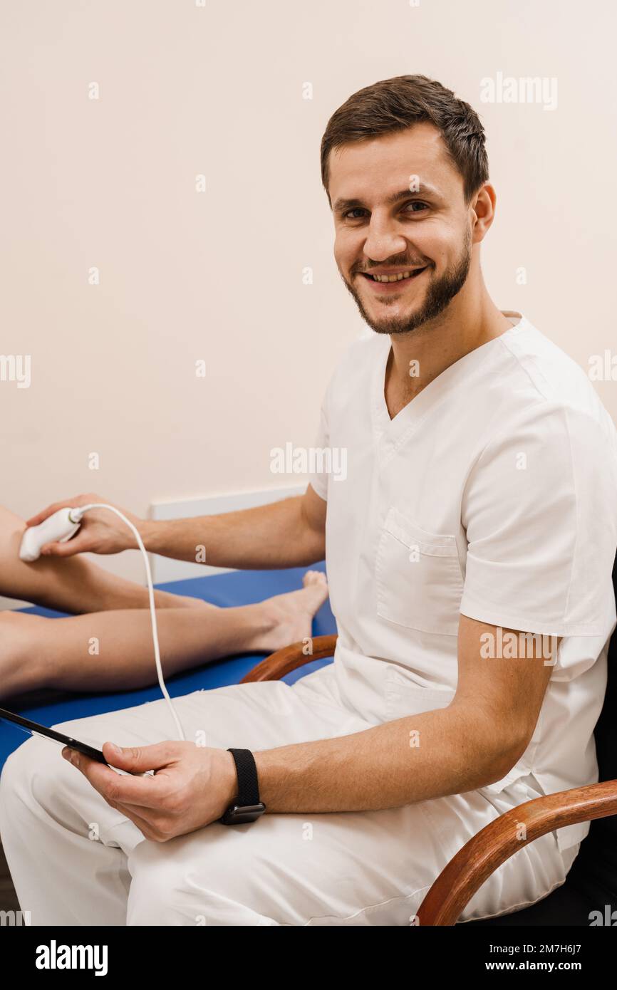 Vascular surgeon examines arteries and veins of legs using portable ...