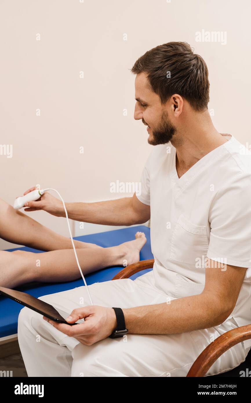 Vascular surgeon examines arteries and veins of legs using portable ...