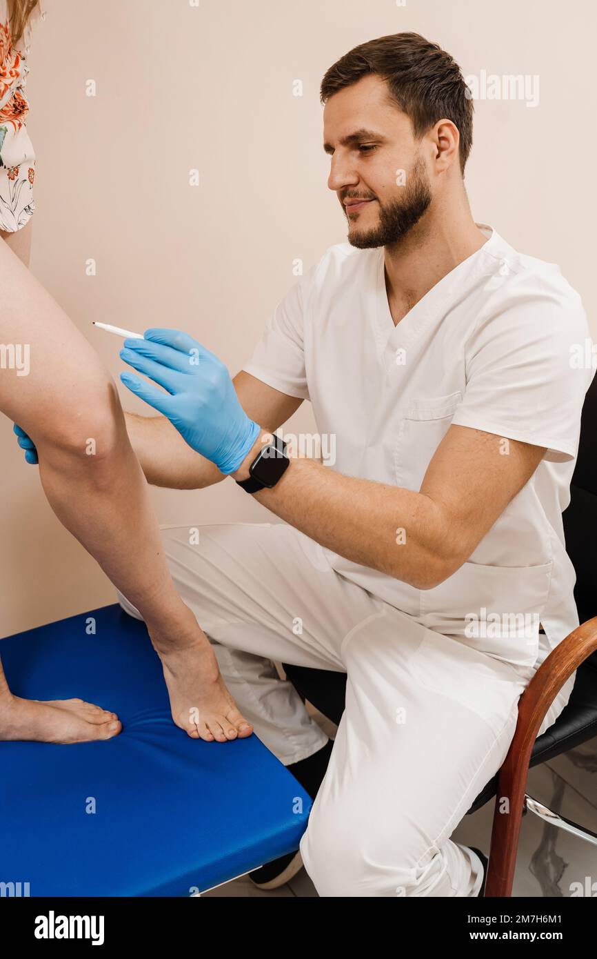 The vascular surgeon is marking leg veins. Vein markup. The ...