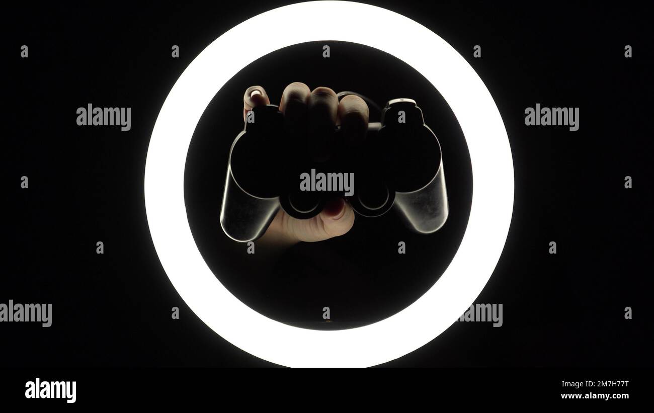 female hands hold a gamepad on a black background. joystick controller ...
