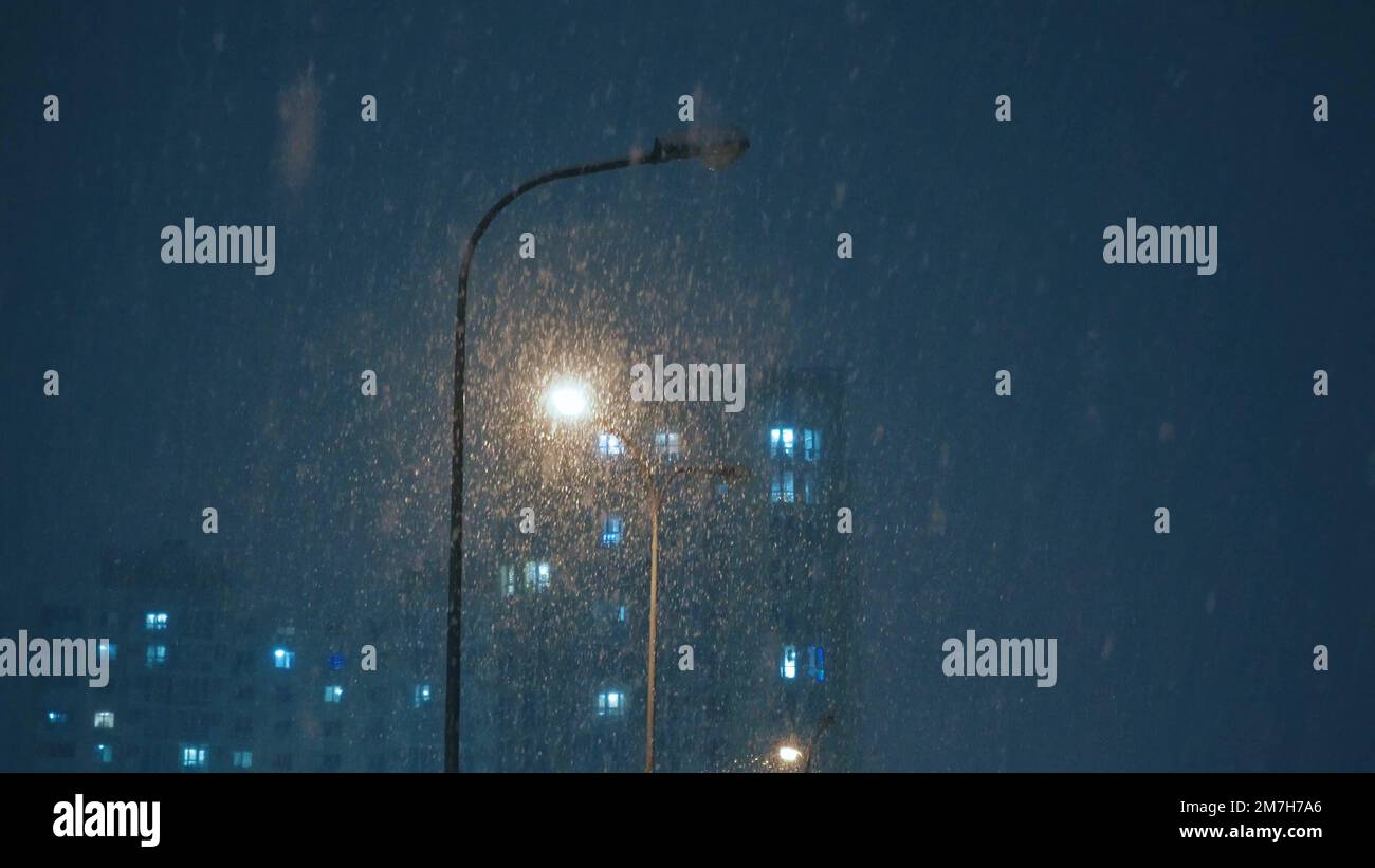 Heavy snowfall. Snow falls on the background of the building. Night ...