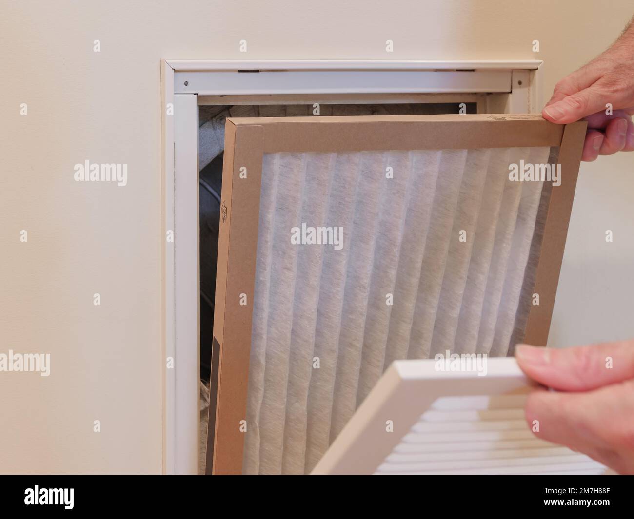 HVAC service technician replacing dirty indoor air filter in ...