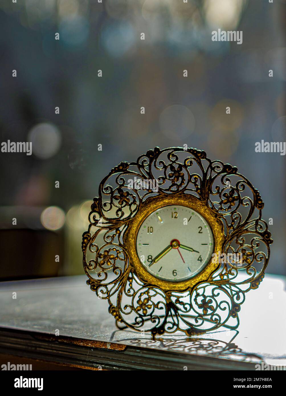 Bokeh background shows retro desk clock on a white table in the ...