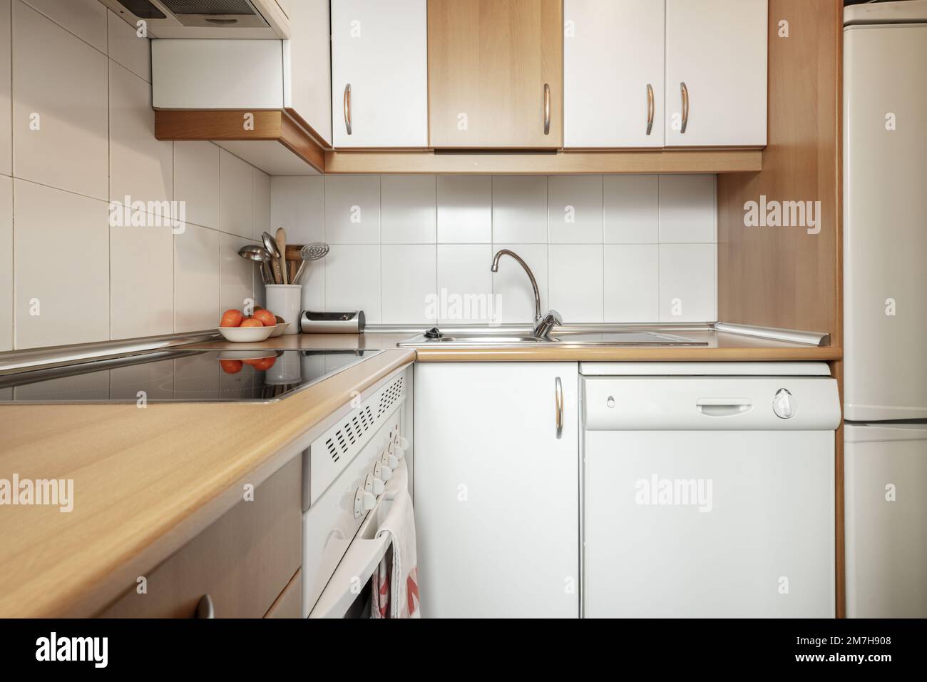 Corner of a kitchen with white cabinets combined with wood with ...