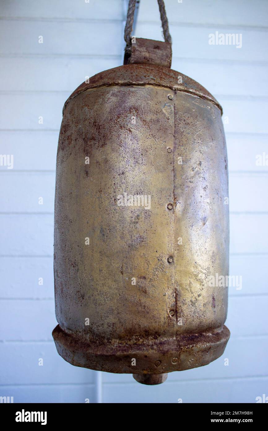 A vertical image of an old bell for cows bell on a white background ...