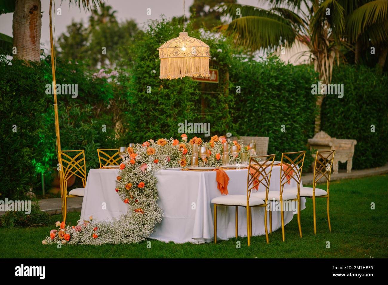 Banquet table near chandelier with light on Stock Photo - Alamy