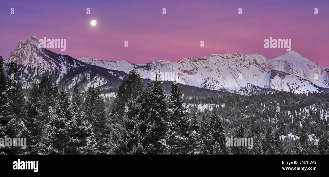 panorama of a full moon setting in a pre-dawn sky above the bridger ...