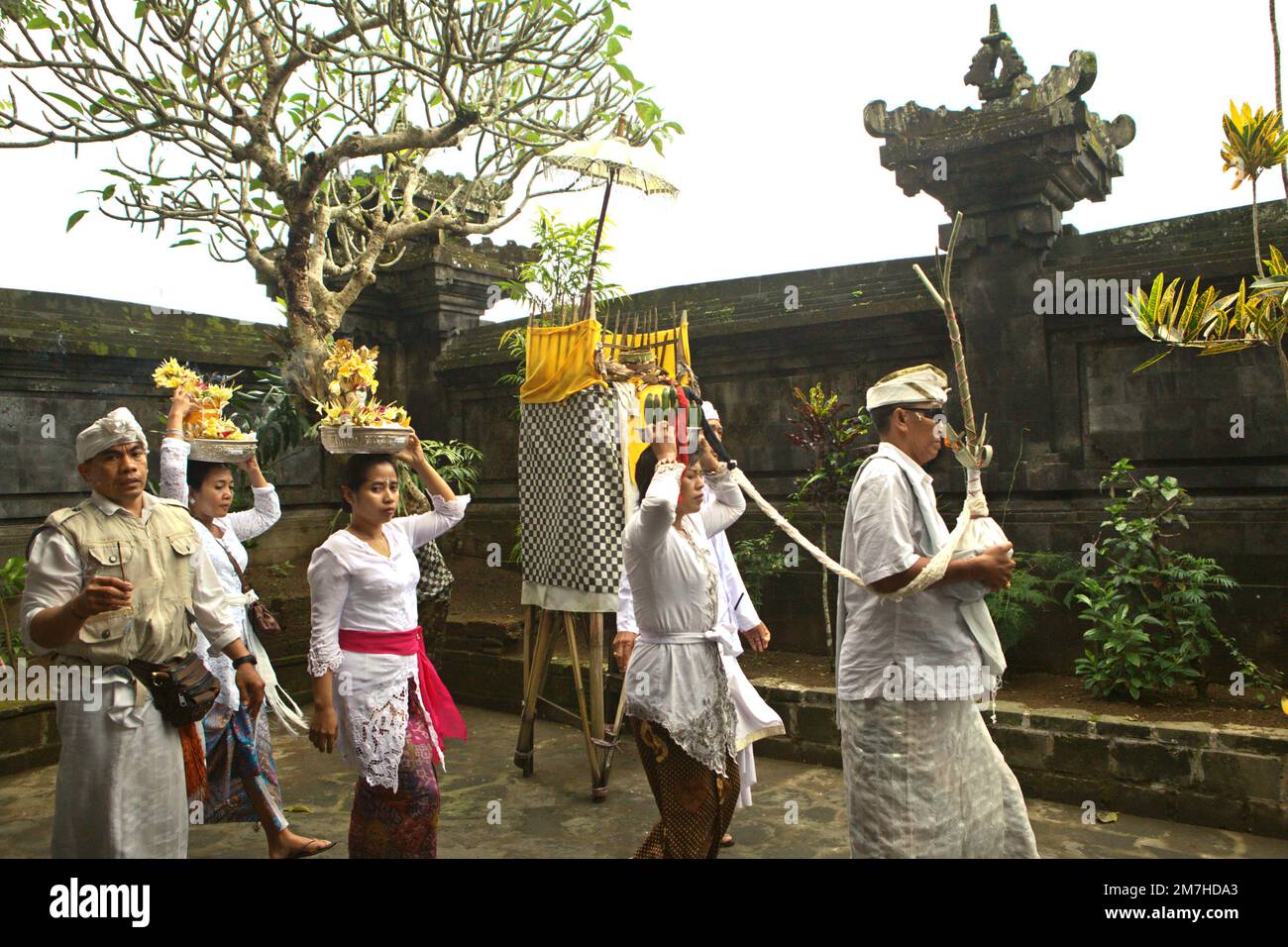 A Balinese clan is walking together as they are carrying spiritual ...