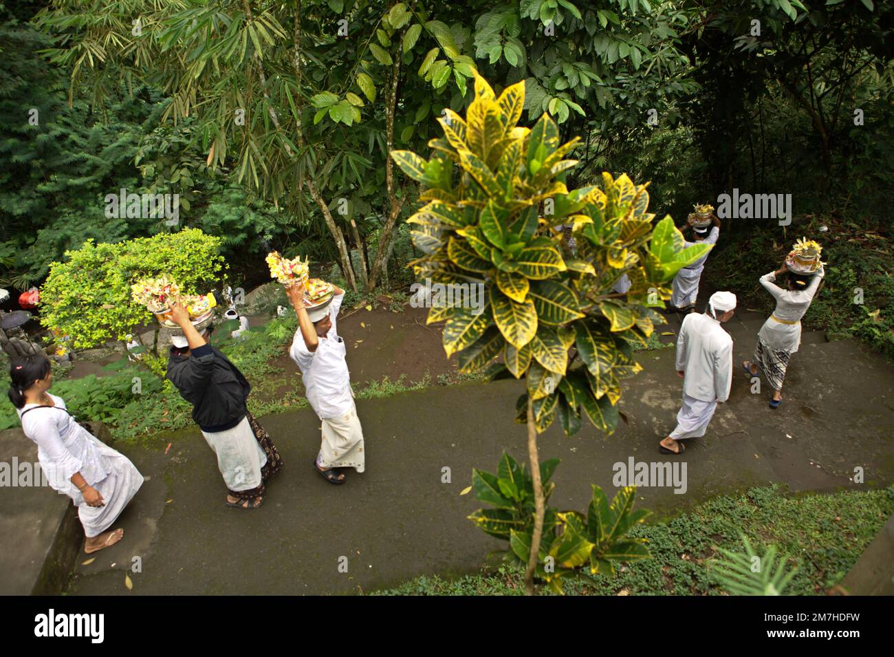 A Balinese clan is walking together as they are carrying spiritual ...