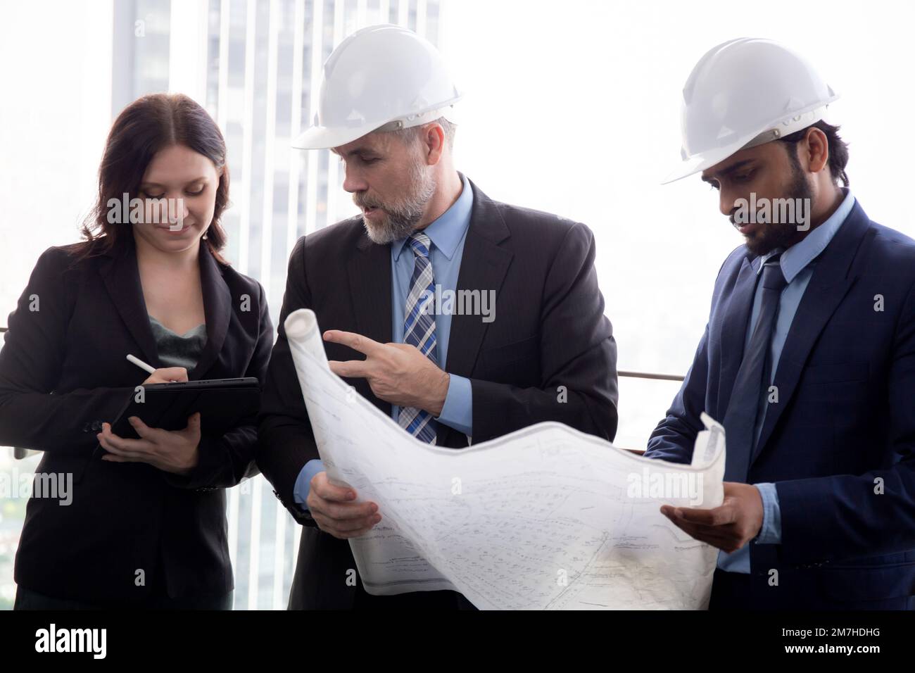 Senior architect and secretary inspector check blueprint and structure ...
