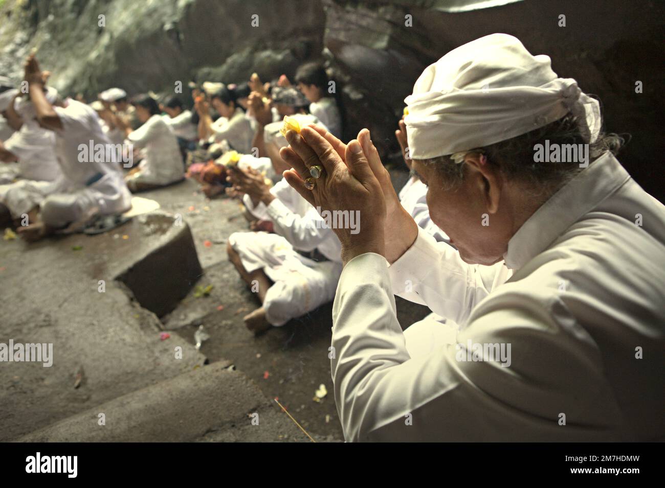 A Balinese clan is praying together during a ritual to honor and purify ...