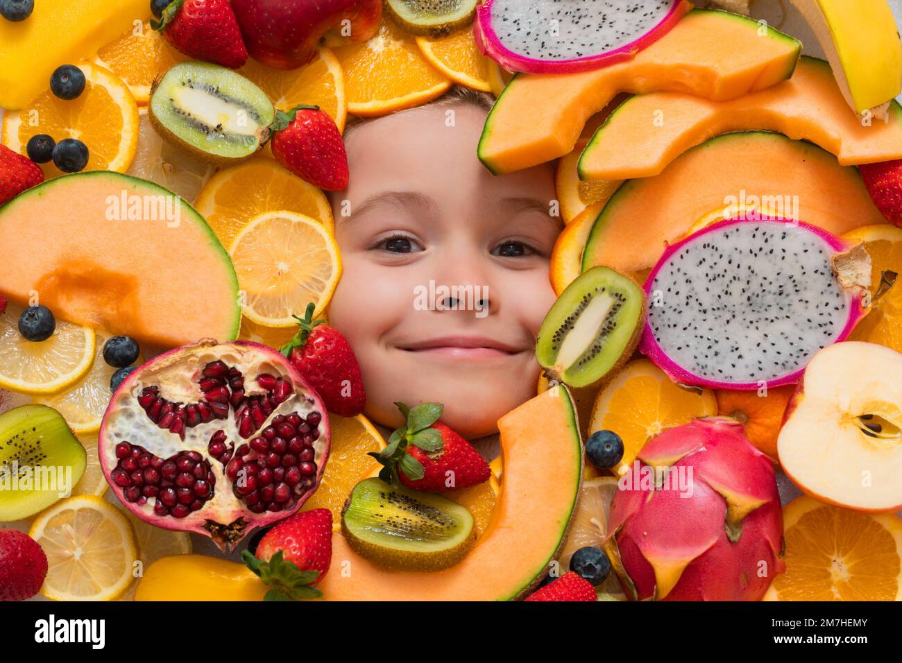 Happy smiling child face with fruits. Kids face with mix of strawberry ...