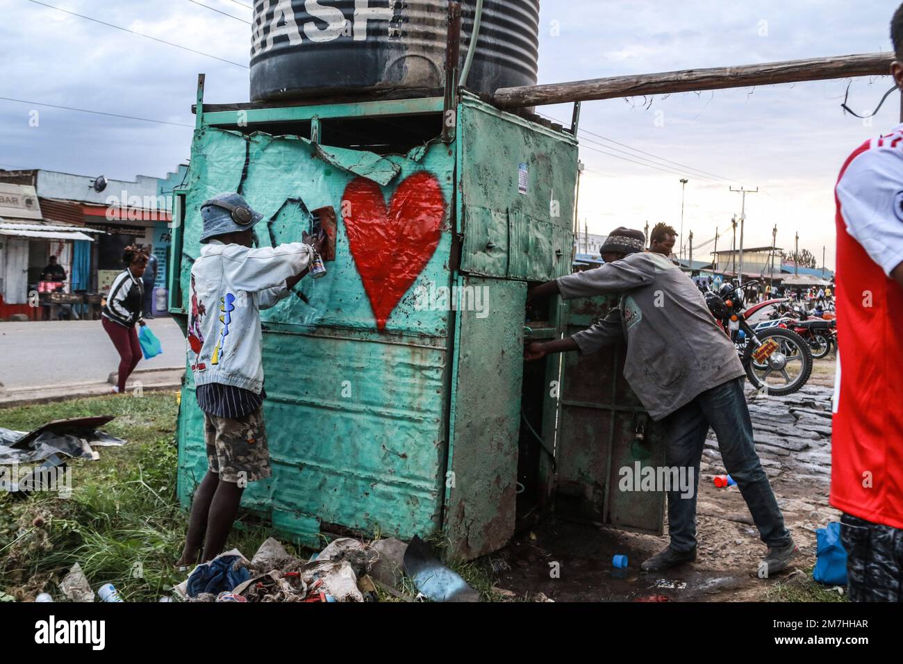 A graffiti artist paints a love mural on a makeshift shelter during a ...