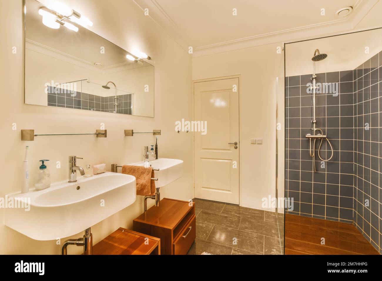 a bathroom with blue tiles on the walls and wooden bench in front of ...